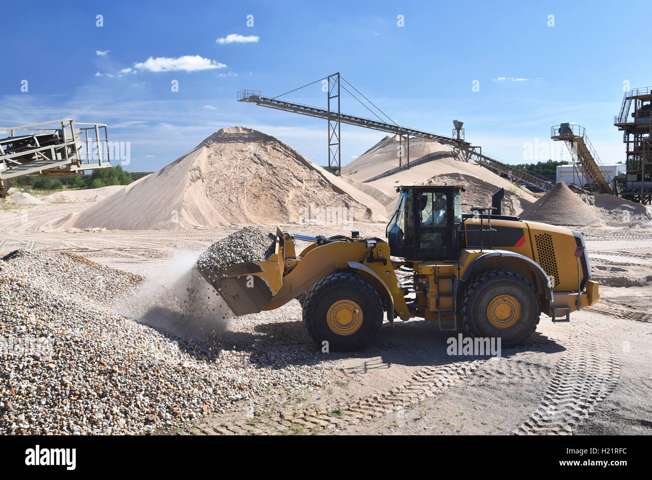 Wheel loader loading stones in gravel pit Stock Photo - Alamy