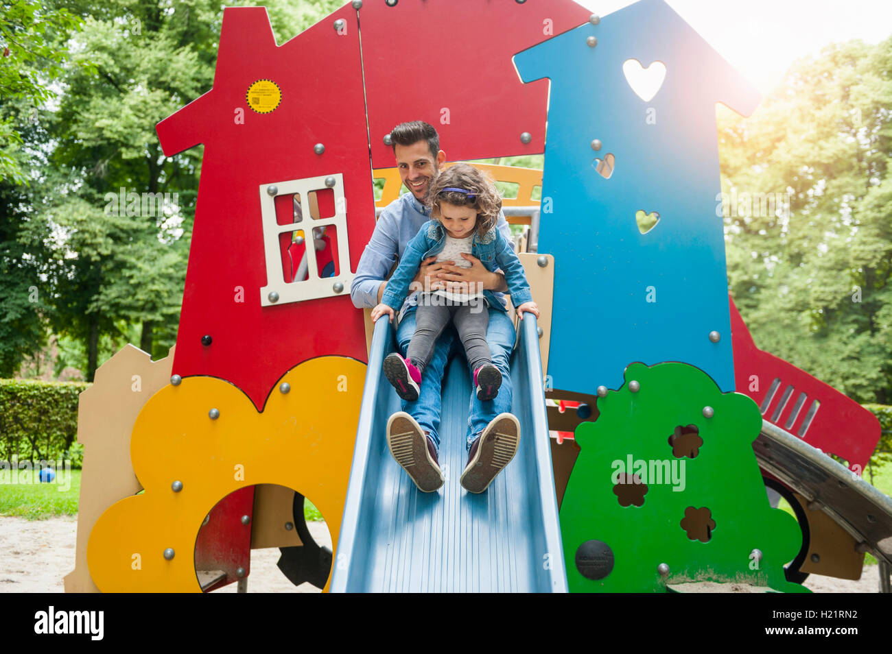 Father with daughter on playground slide Stock Photo - Alamy