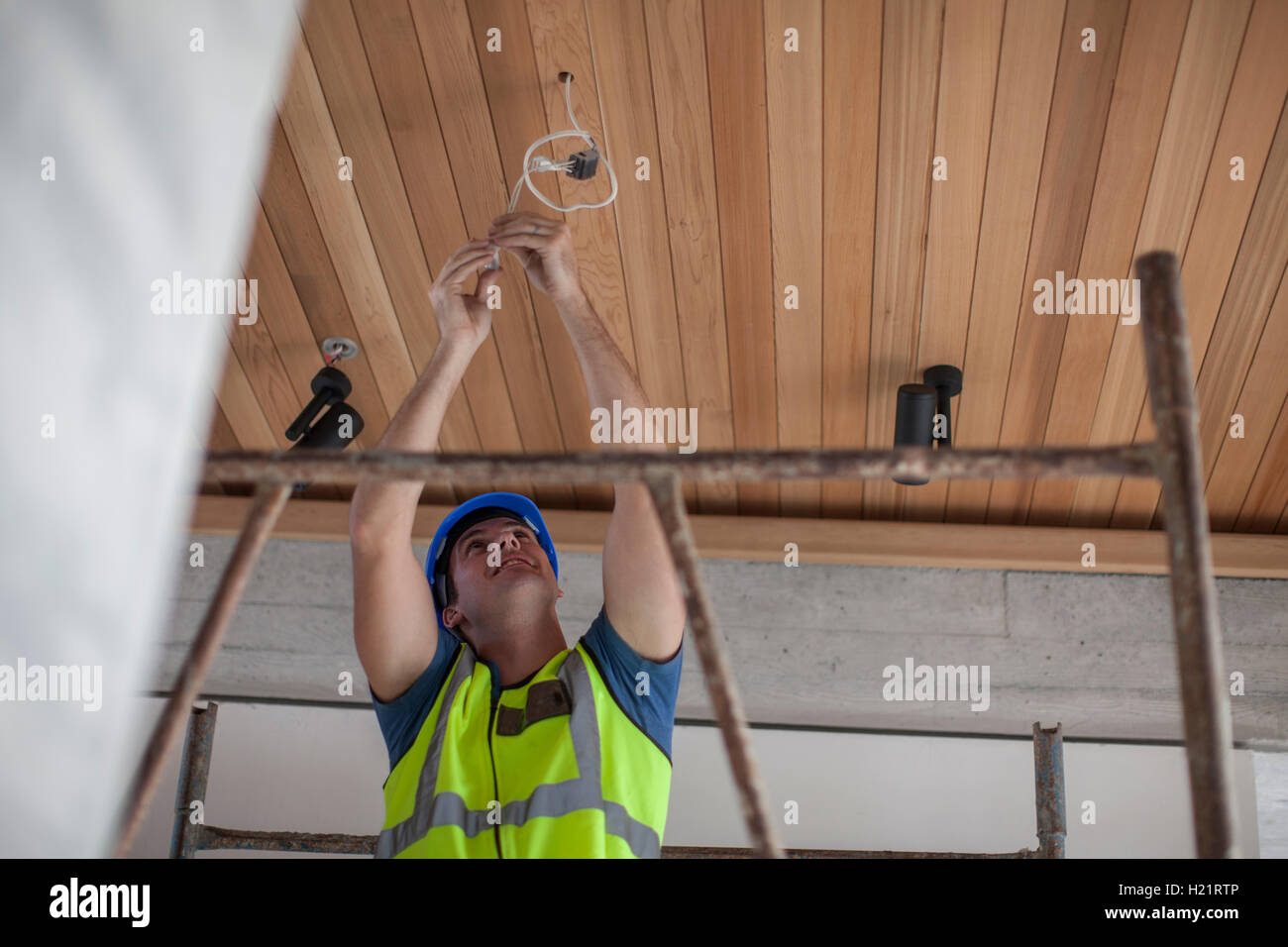 Electrician fixing cable at ceiling Stock Photo - Alamy