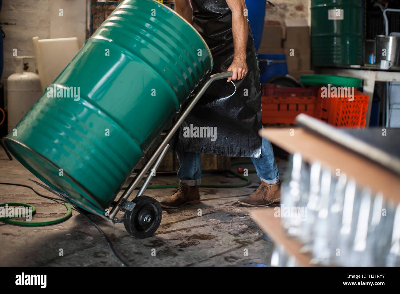 Man pushing metal container in a warehouse Stock Photo - Alamy