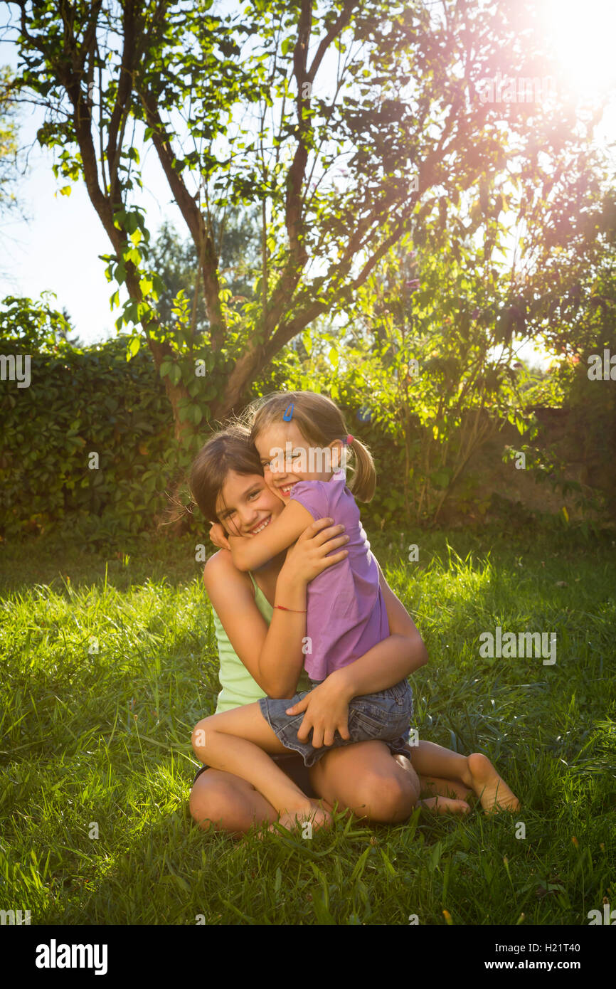 Two sisters playing together on a meadow Stock Photo - Alamy