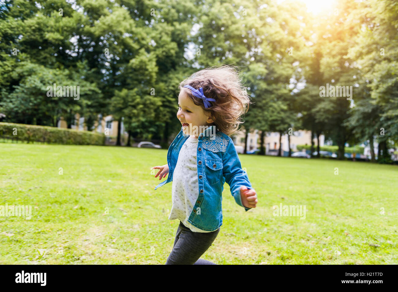 Happy girl running on meadow in park Stock Photo - Alamy
