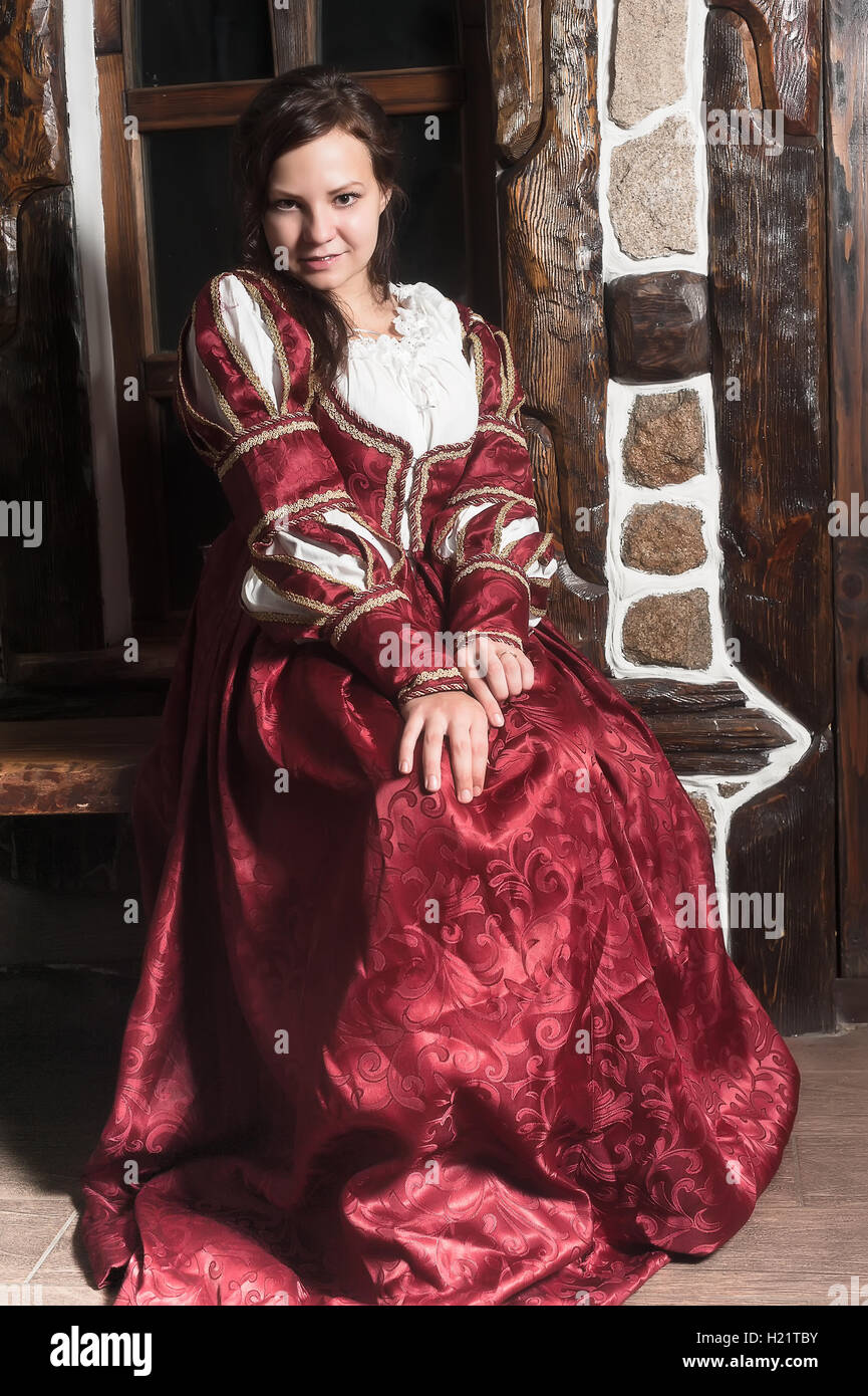 Medieval style portrait of attractive woman in red dress with wine ...
