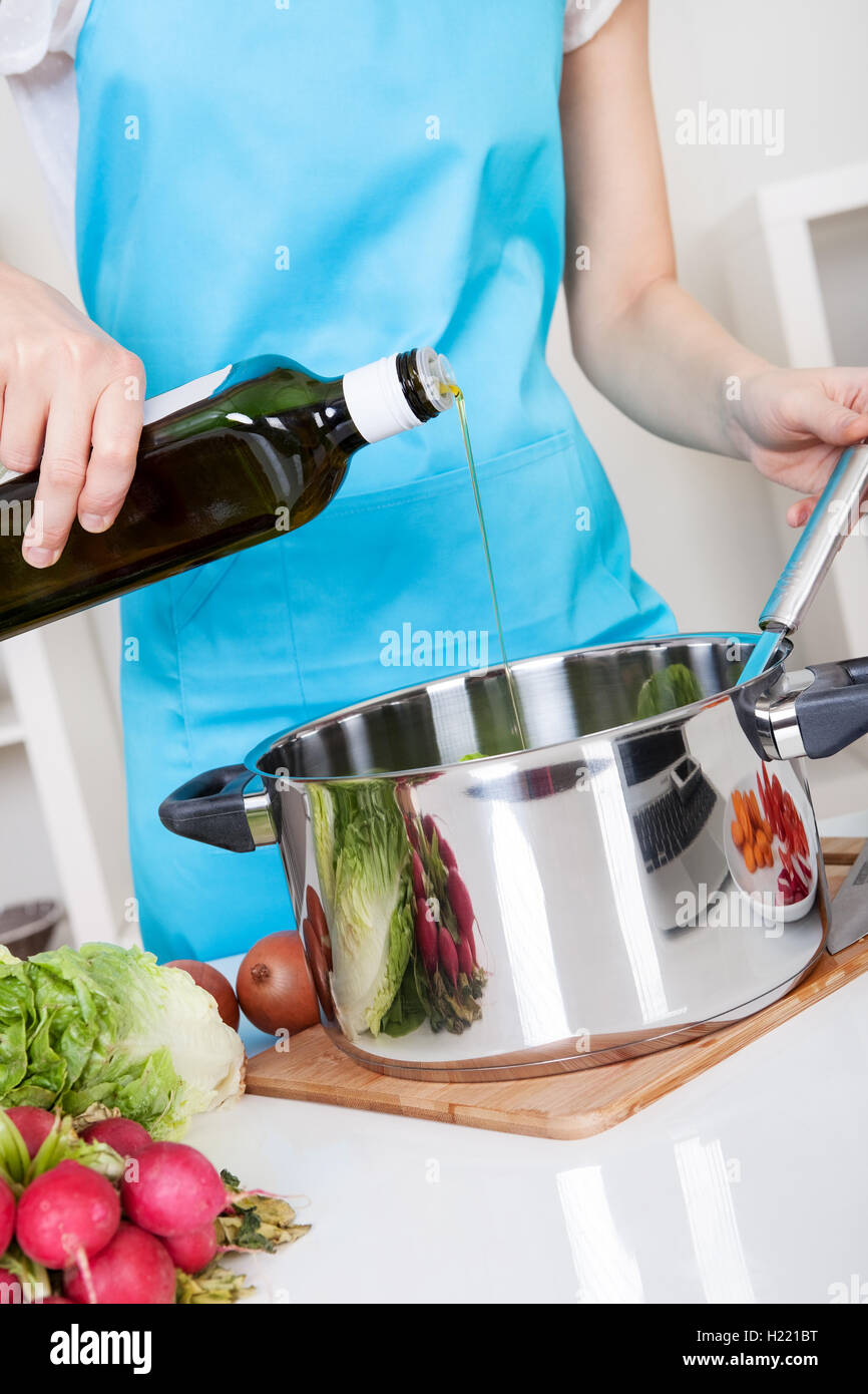 Cheerful young woman cooking Stock Photo - Alamy