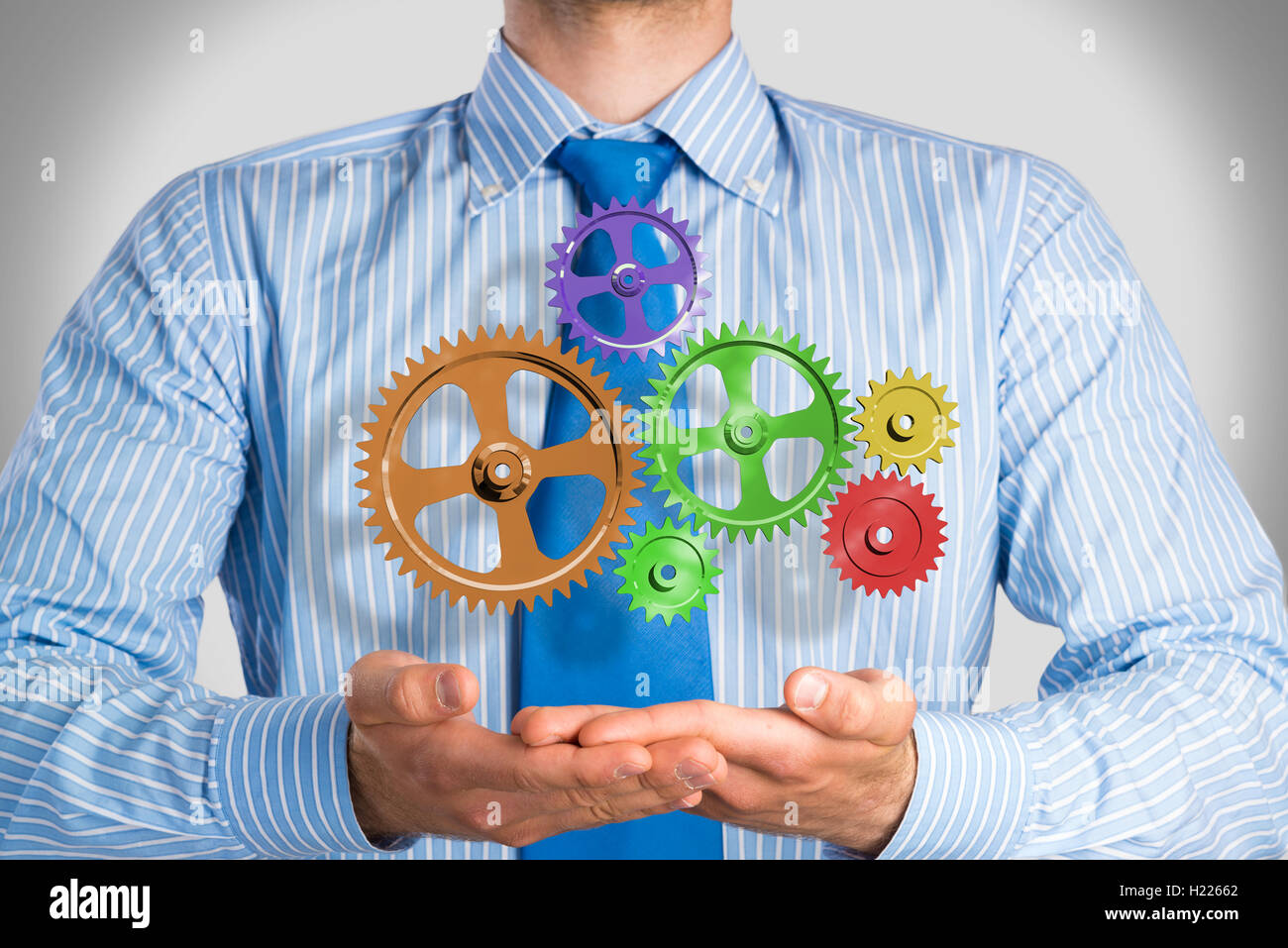 business man holds up a mechanism of gears Stock Photo - Alamy