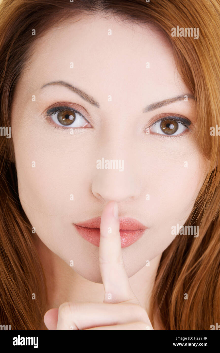 Woman with finger on her lips Stock Photo - Alamy