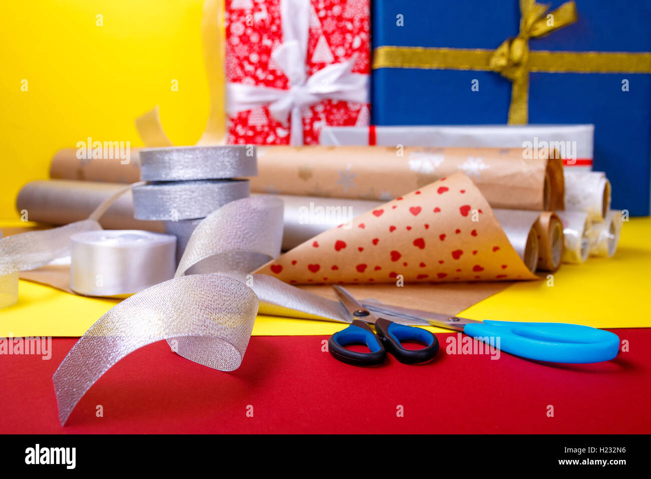 Gift wrapping, boxes, paper, ribbon and scissors on color background ...