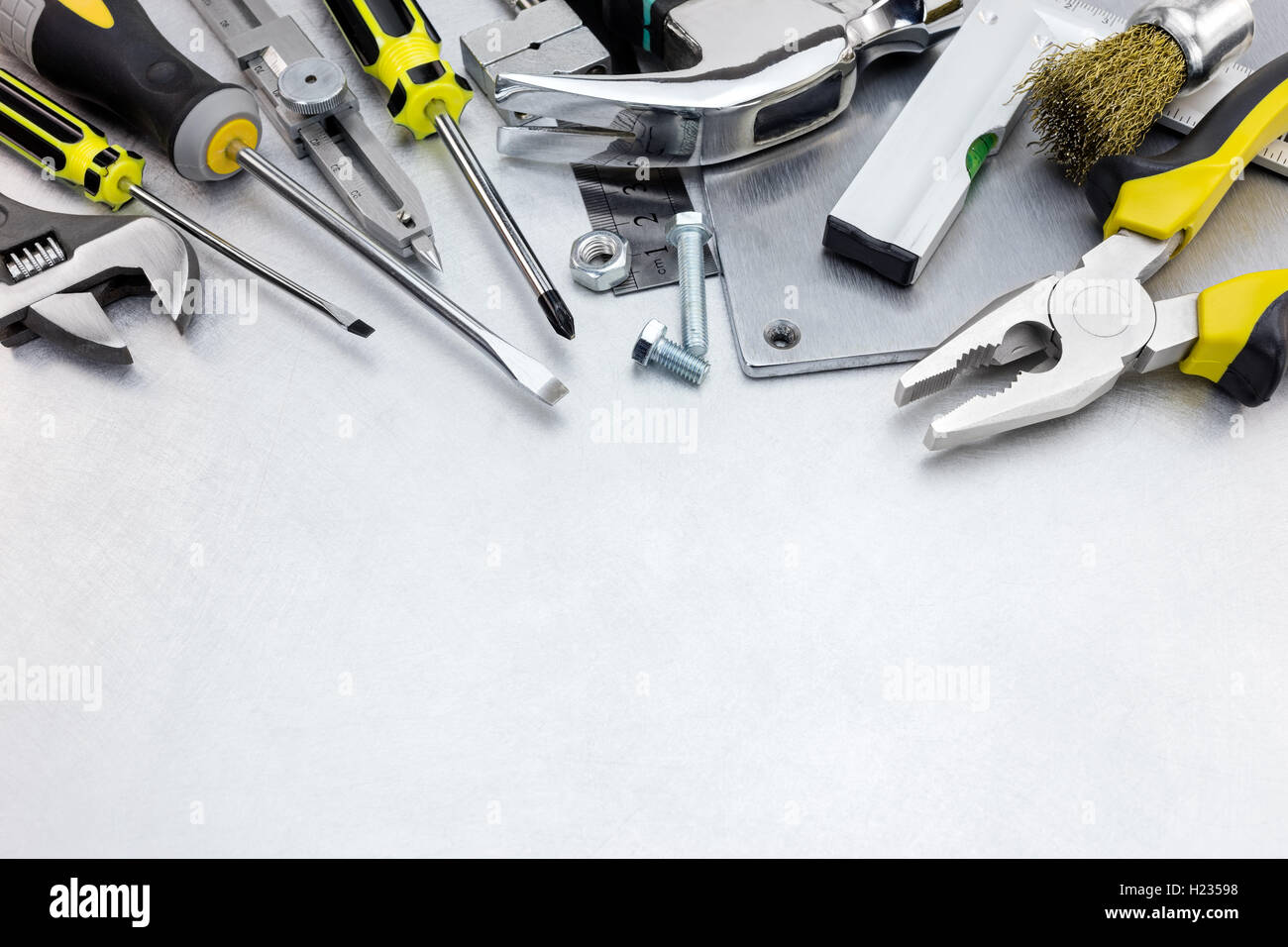 scratched metal background with yellow tool set and instruments for ...