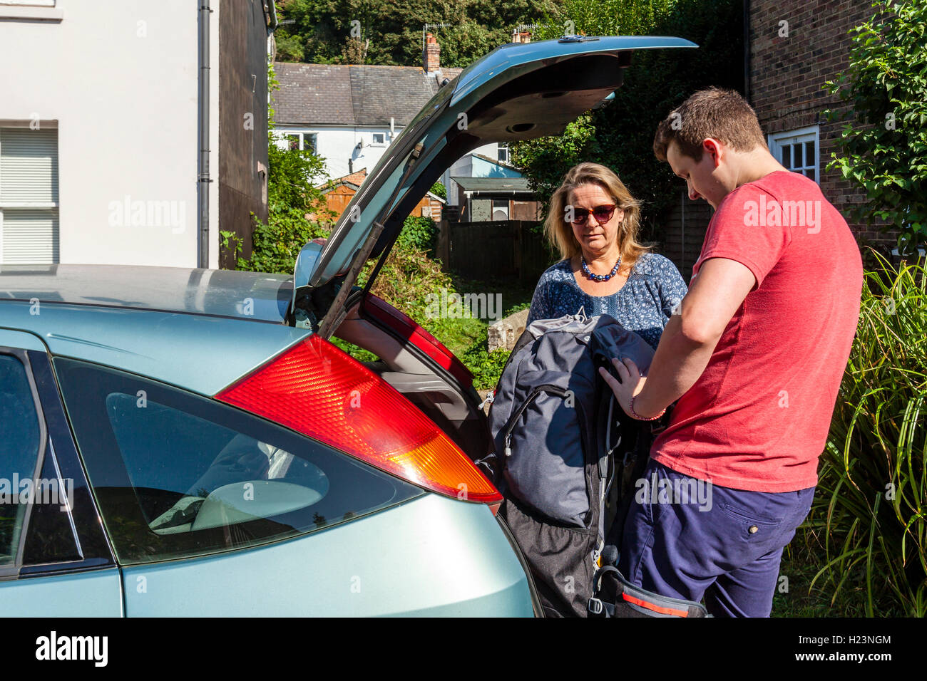 A Young Man Puts His Backpack Into A Car To Go Travelling, Sussex, UK ...