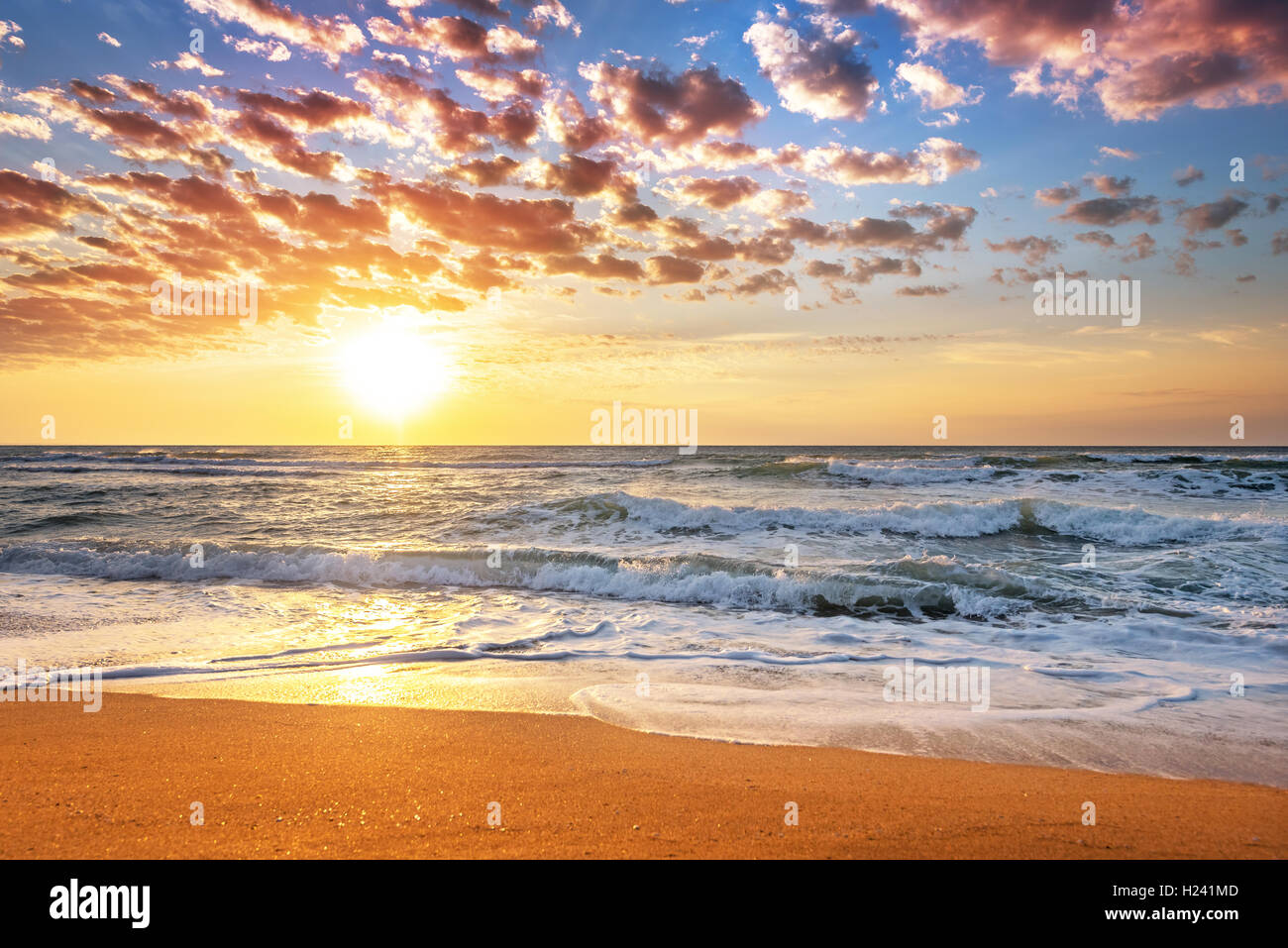 Colorful ocean beach sunrise with deep blue sky and sun rays Stock ...