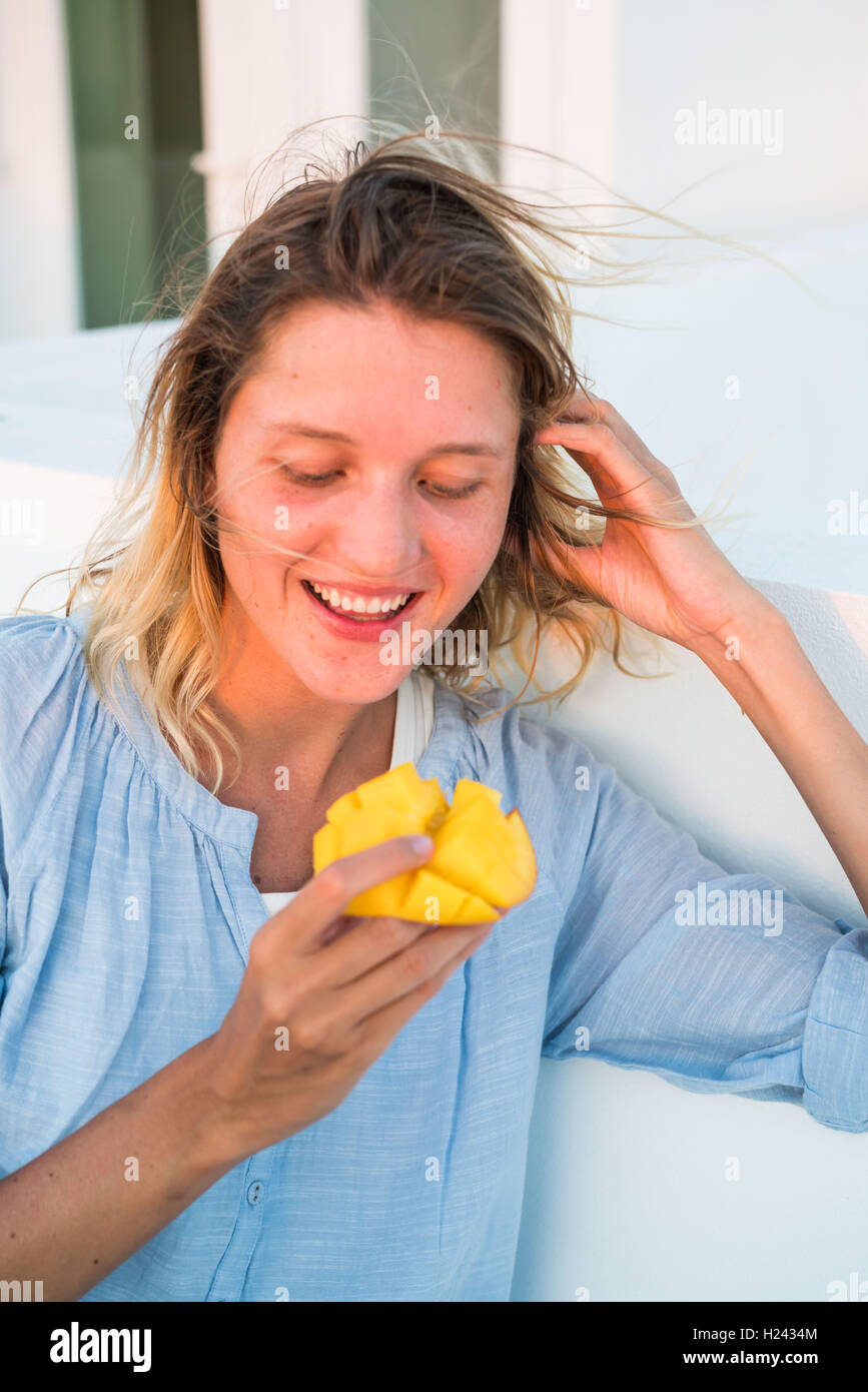 Woman eating mango Stock Photo - Alamy