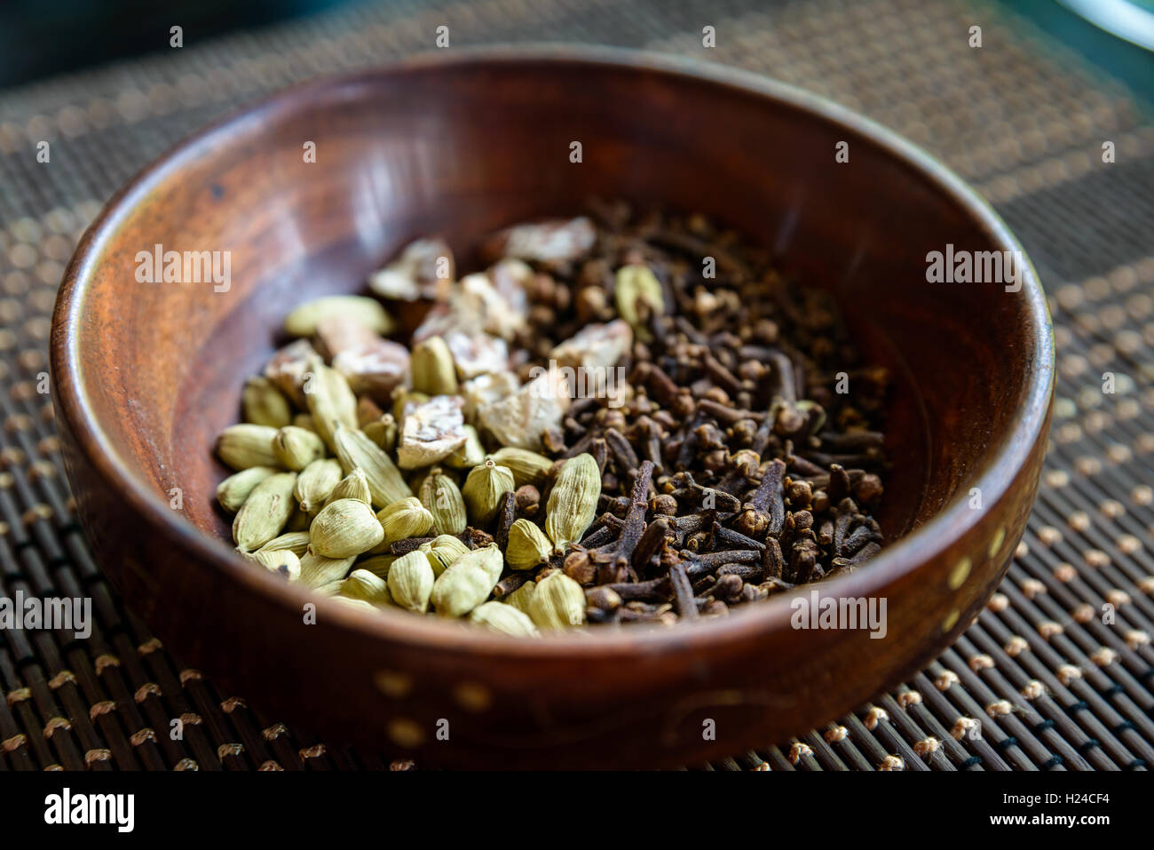 Cardamon, cloves and areca nuts in wooden bowl Stock Photo - Alamy