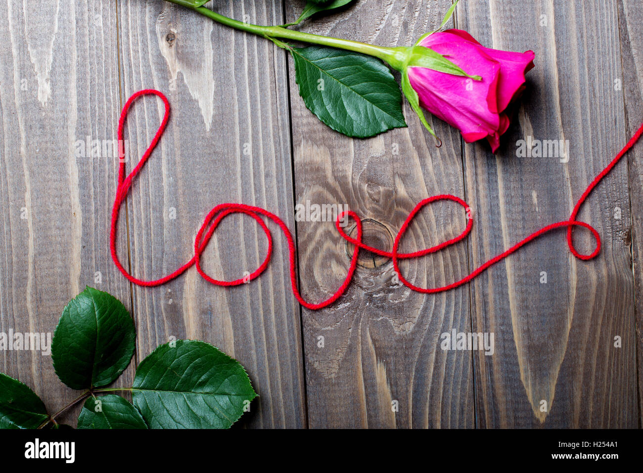 Word "love" written with a red thread Stock Photo - Alamy