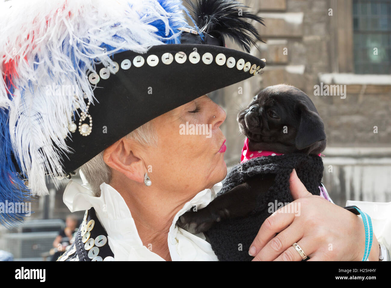 London, UK. 25 September 2016. A Pearly Queen kisses her black pug ...