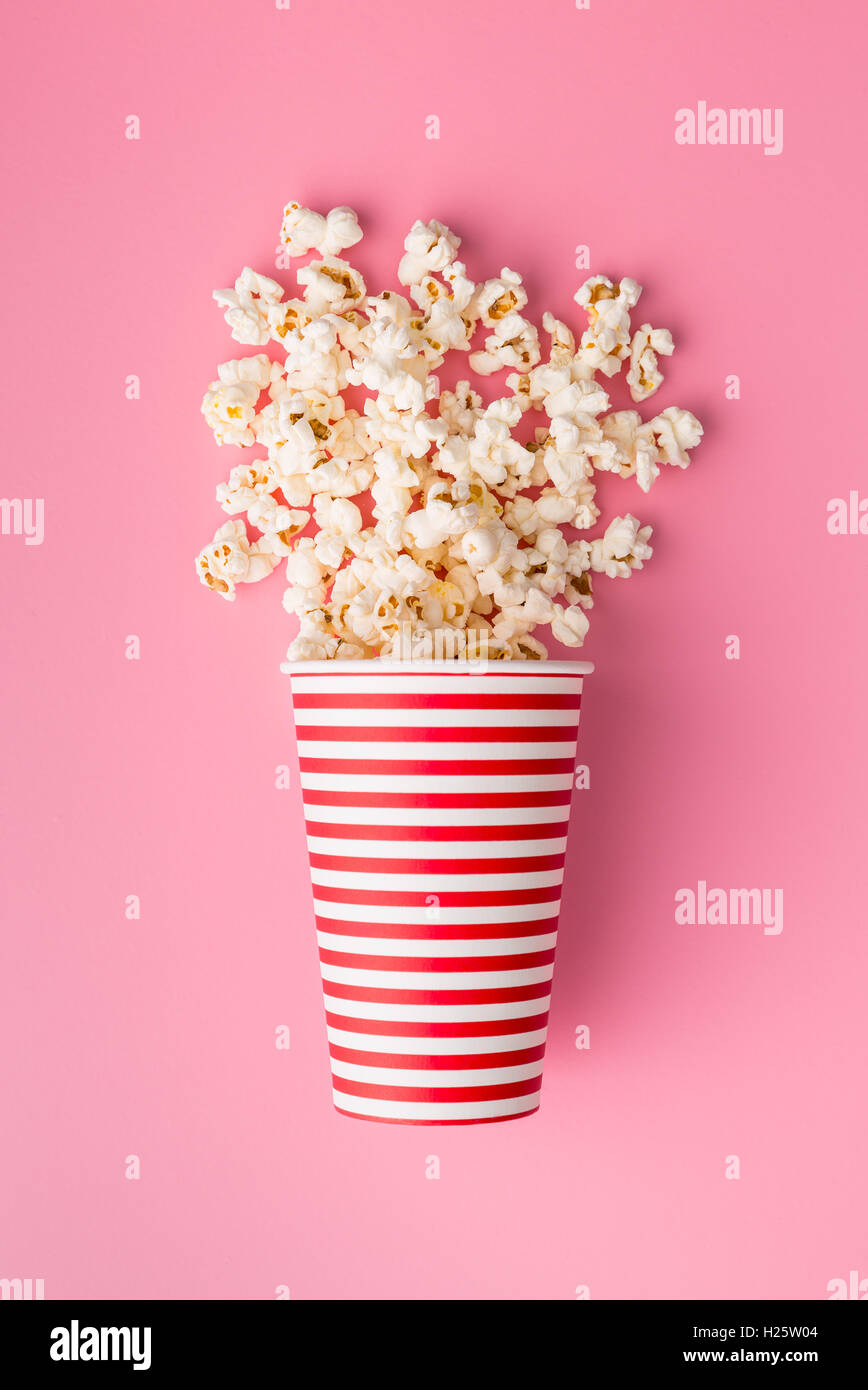 Popcorn in paper cup on colorful background Stock Photo - Alamy