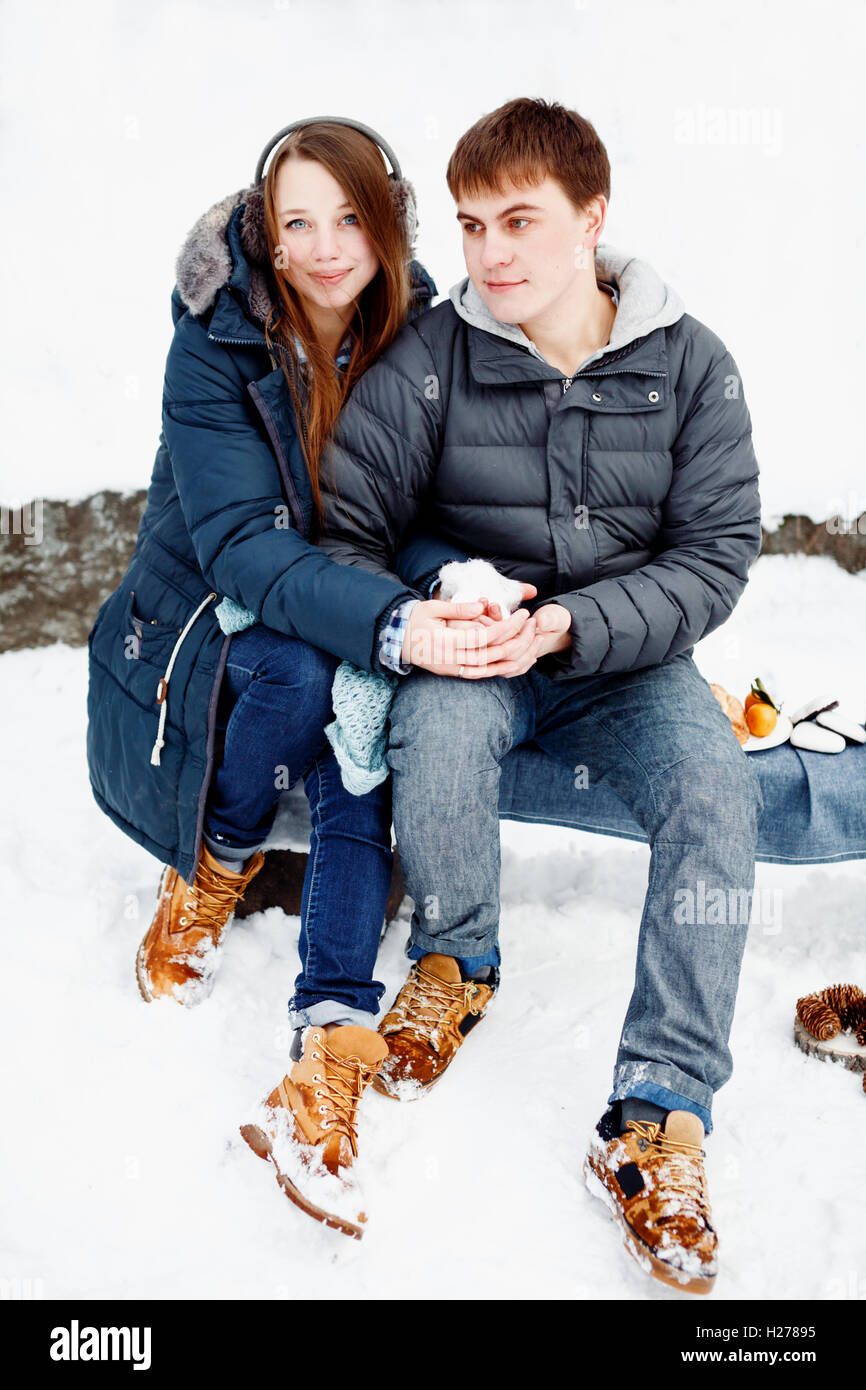 Young lovely couple having fun outdoors in winter park, holding hands. Loving couple outdoors ...