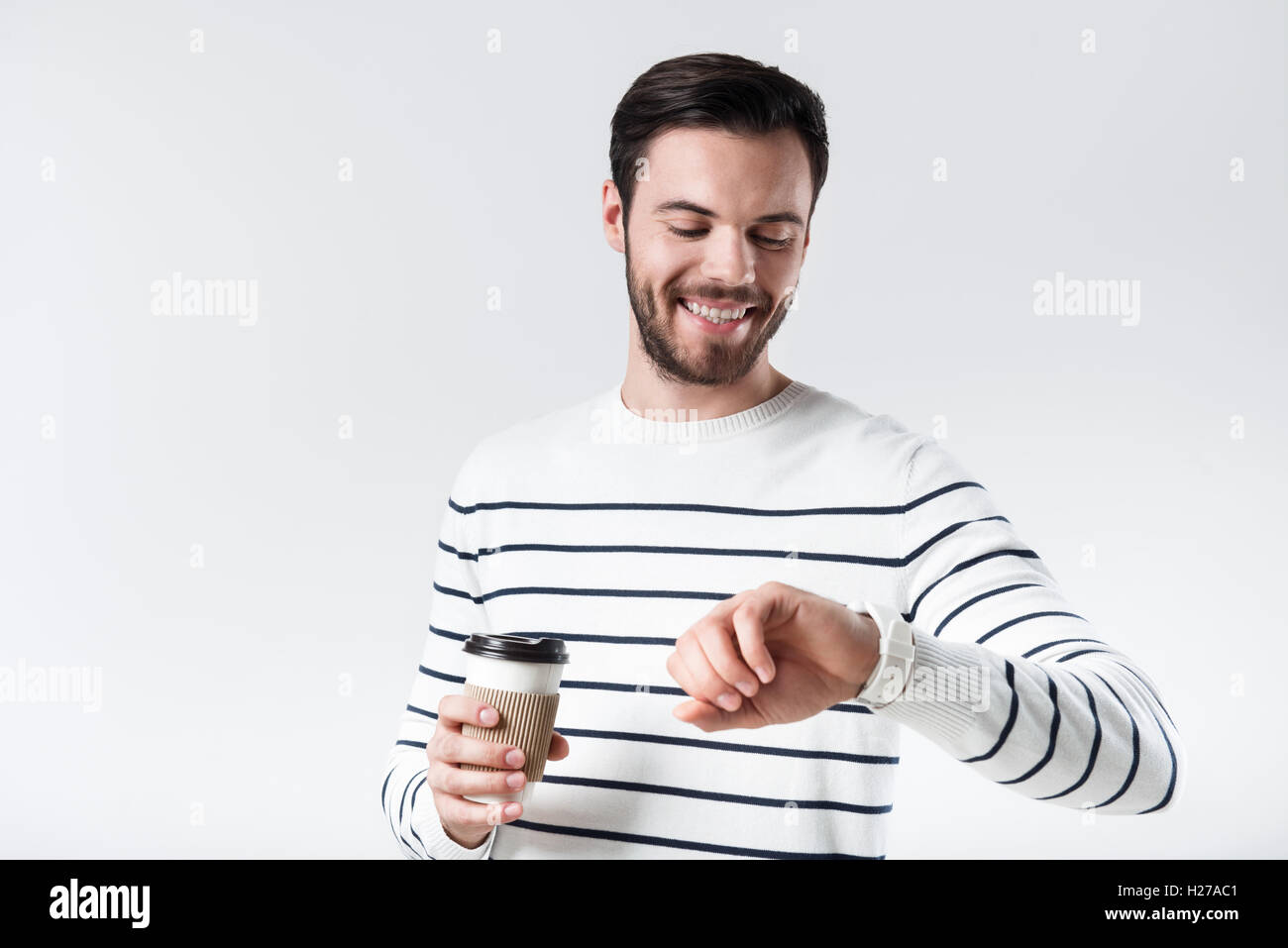 Smiling bearded man looking at watch Stock Photo - Alamy