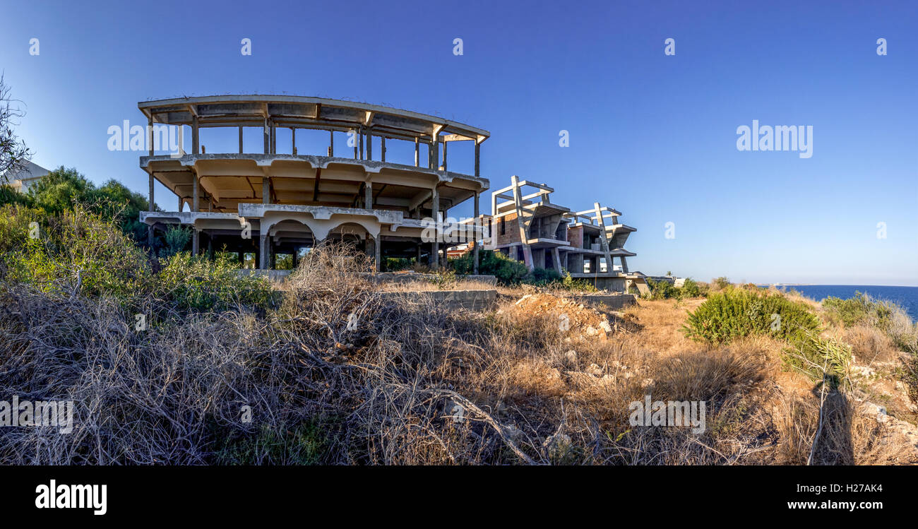 Abandoned half-finished hotel buildings on the seafront at Bogaz in ...
