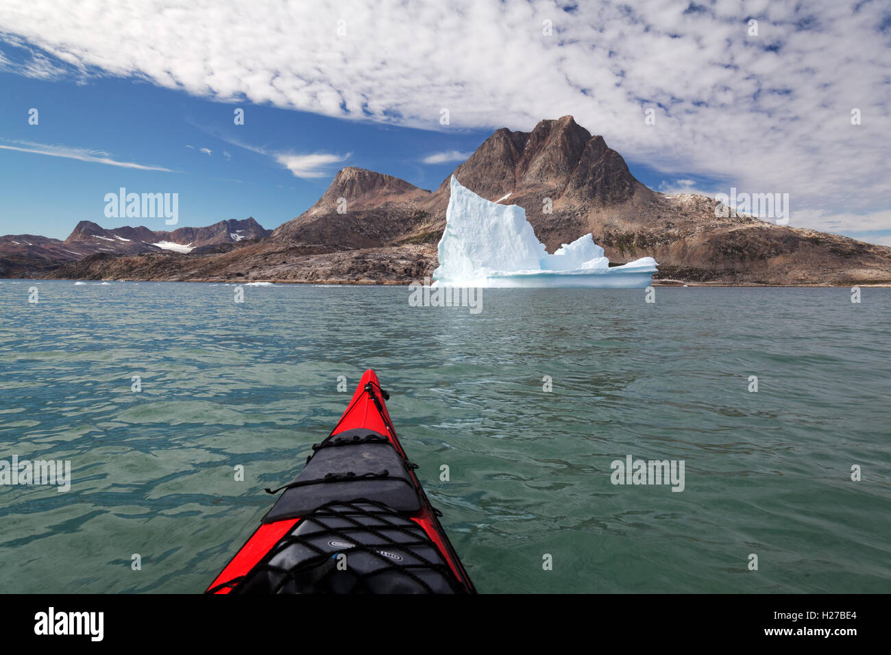 Bow of sea kayak with pinnacled iceberg and mountains, Sammileq Fjord ...