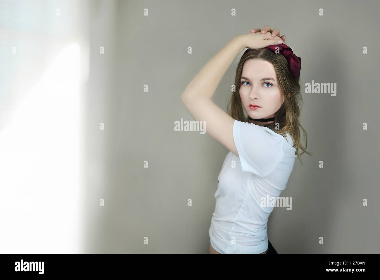 Girl standing with arms over head looking Stock Photo - Alamy