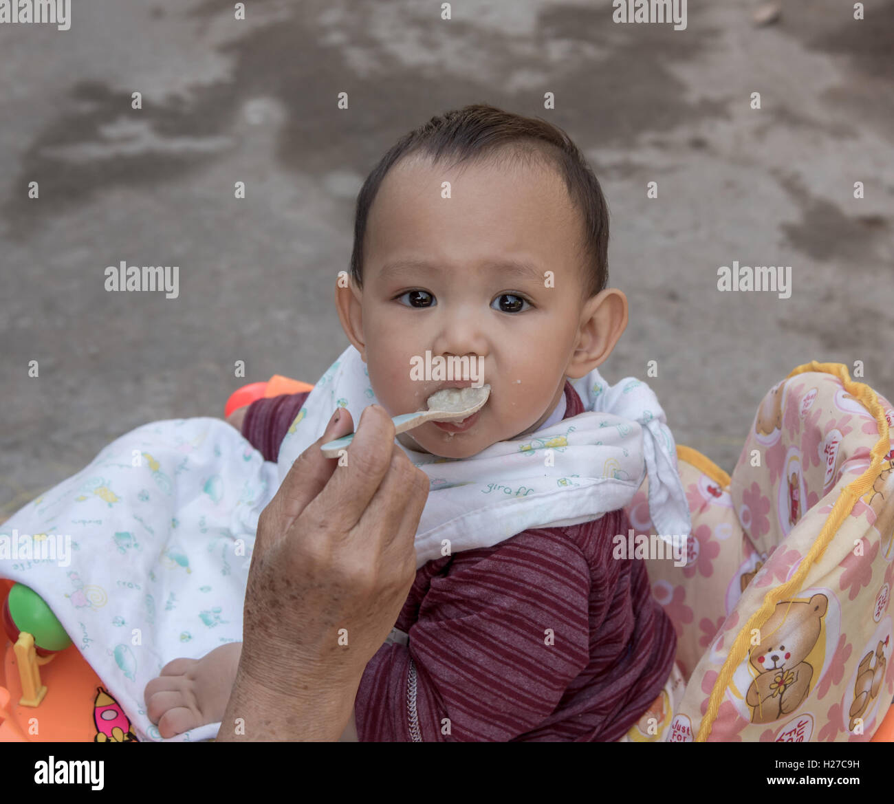 Baby eating food by mother feeding, family scene of Thailand Stock ...