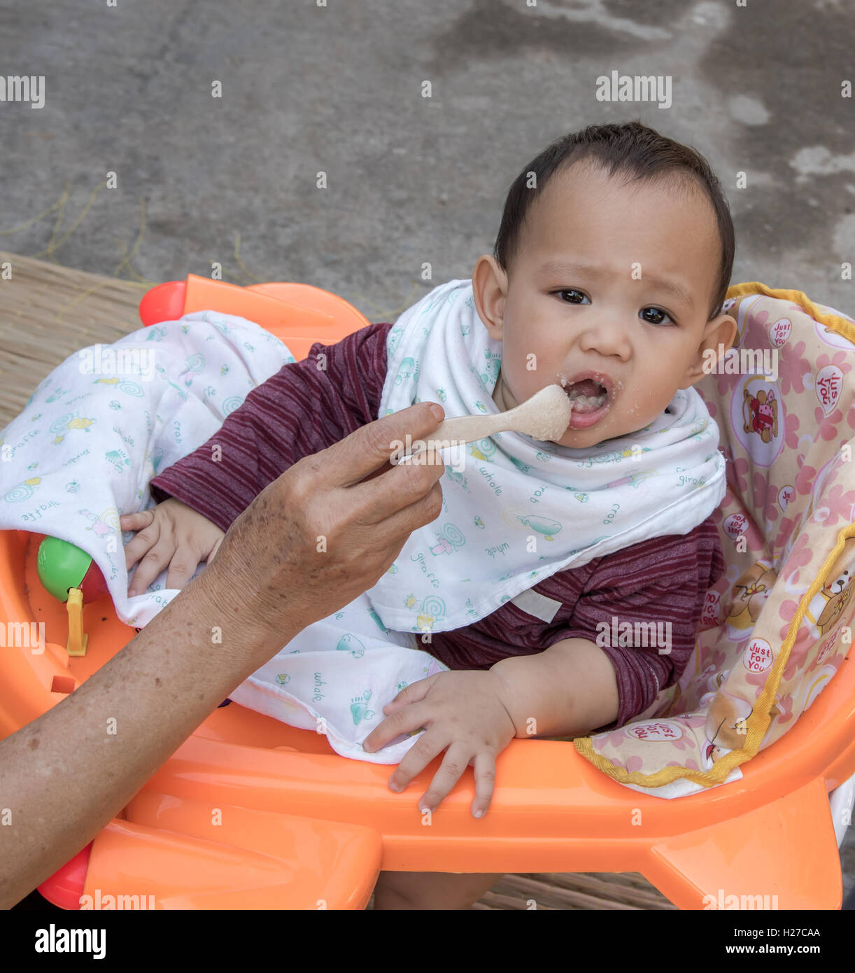 Baby eating food by mother feeding, family scene of Thailand Stock ...