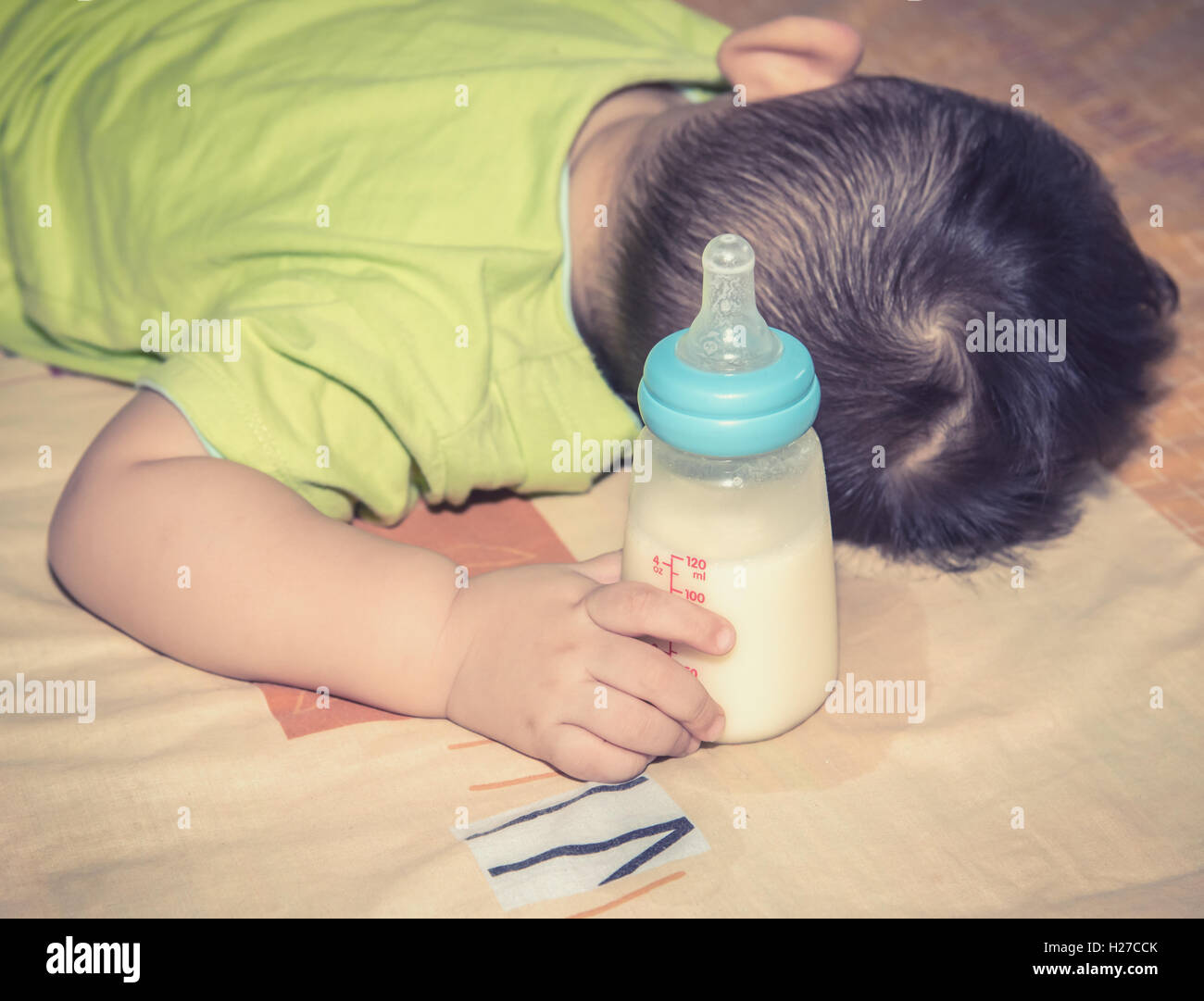 Baby hand hold milk bottle , vignette Stock Photo - Alamy