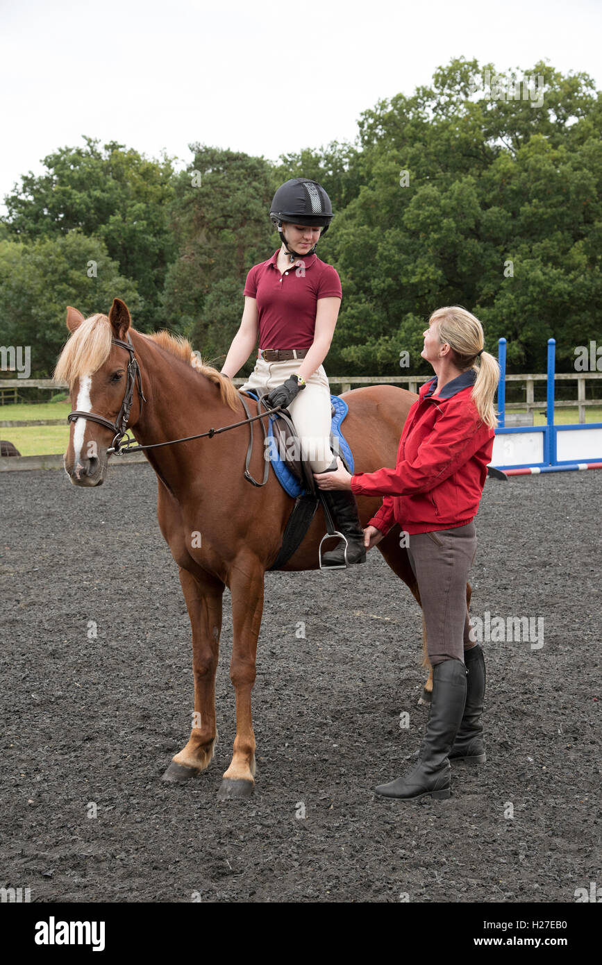 Young pony rider sitting in the saddle. The teenage pupil learning to ...