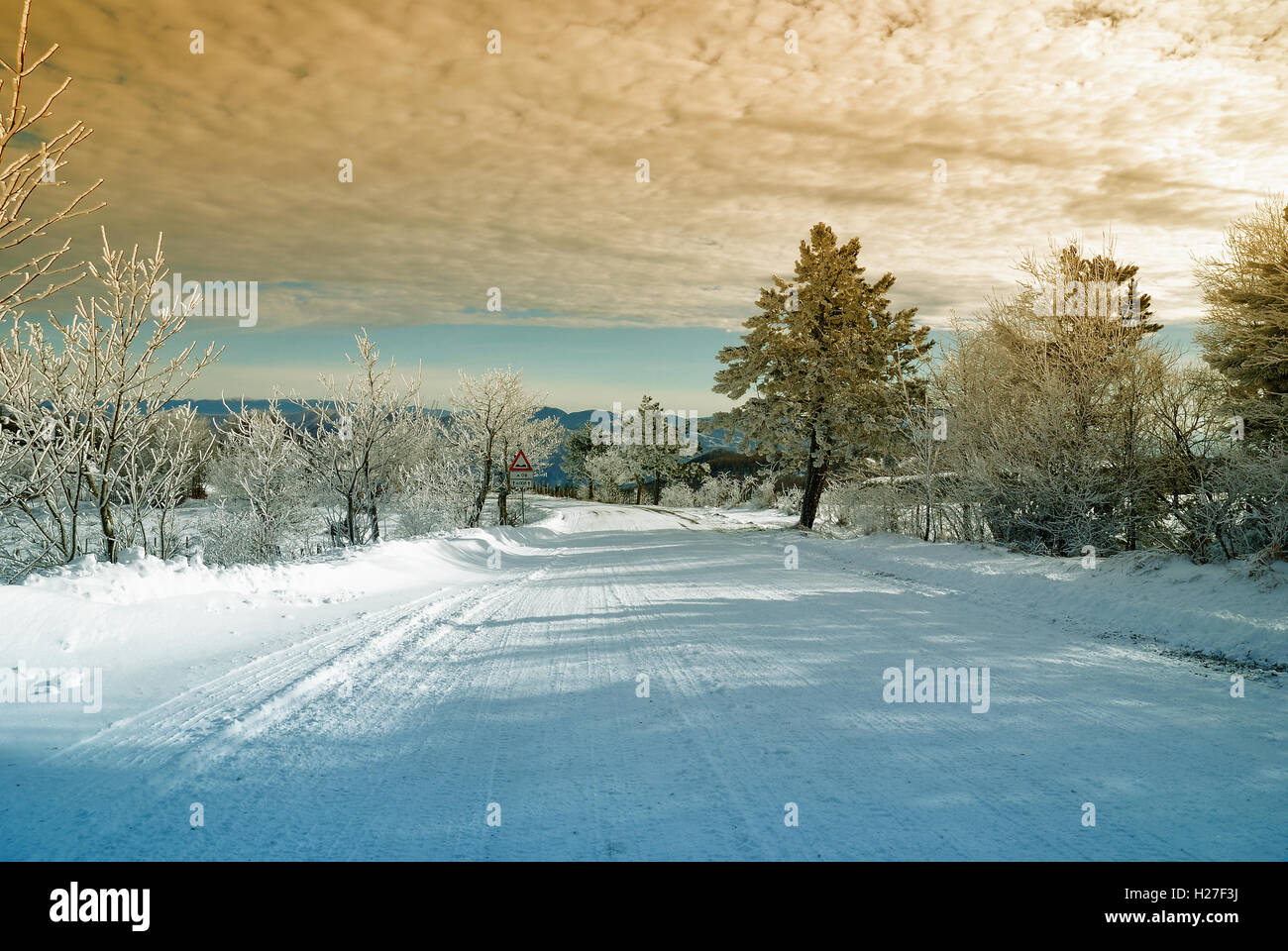 snowy road at sunset with amazing sky Stock Photo - Alamy