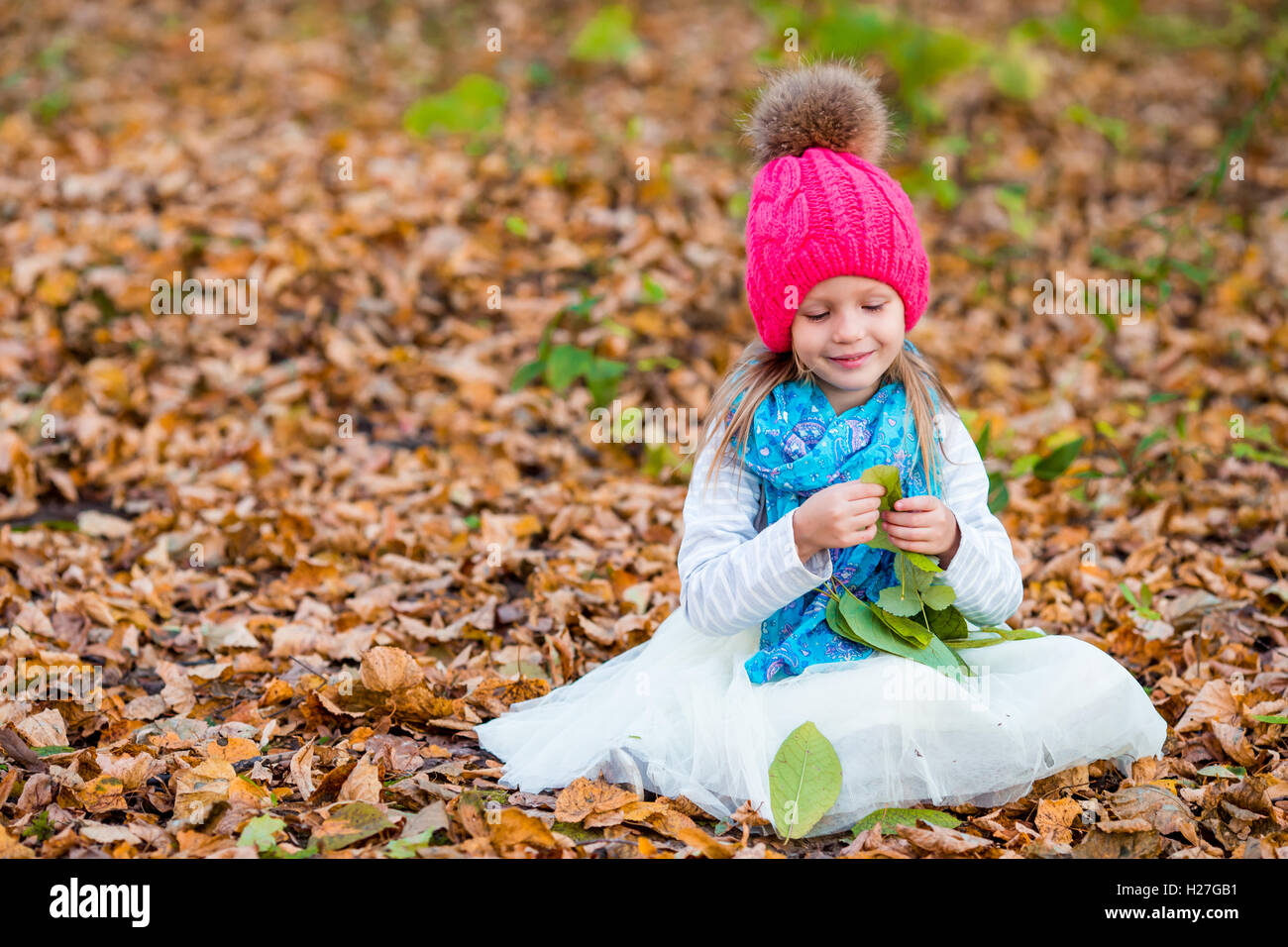 Adorable little girl with colorful leaf at beautiful autumn day Stock ...