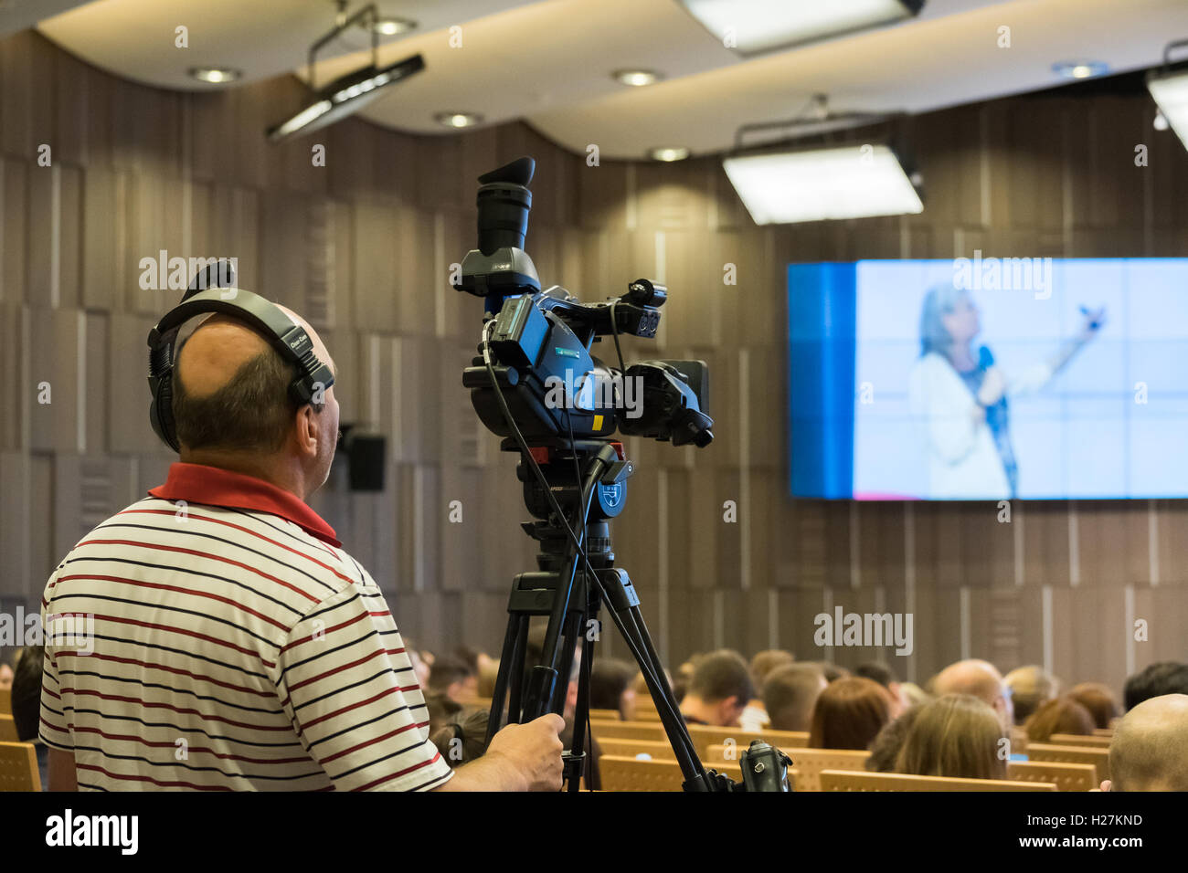 Videographer makes online broadcast at the conference Stock Photo - Alamy