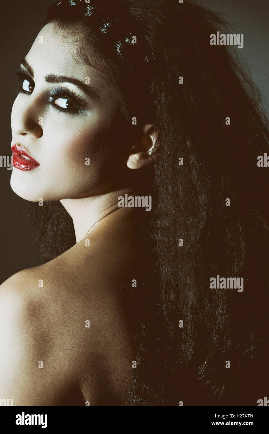 Beautiful young woman looking over shoulder Stock Photo - Alamy