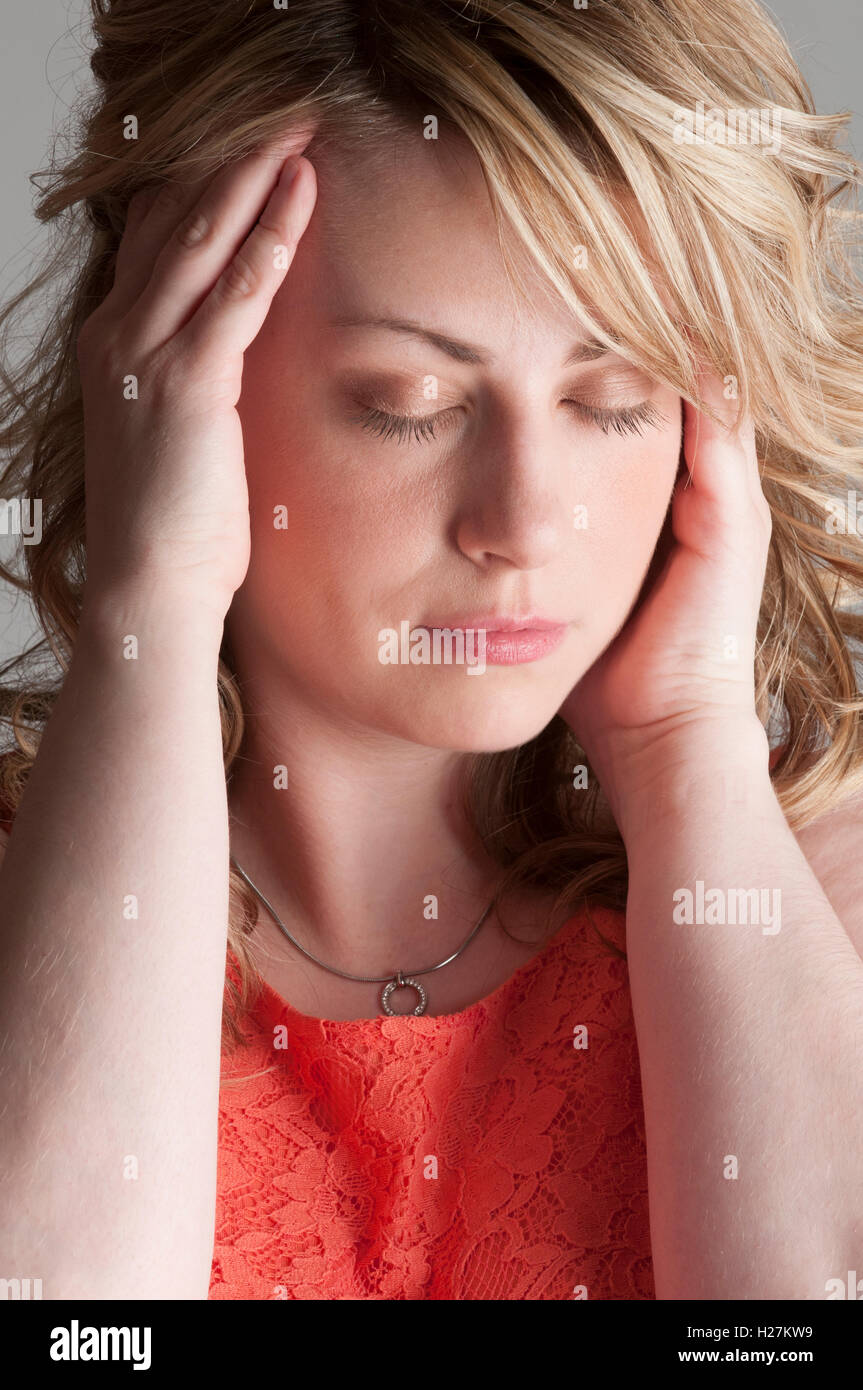 Blond woman hands on head in pain Stock Photo - Alamy