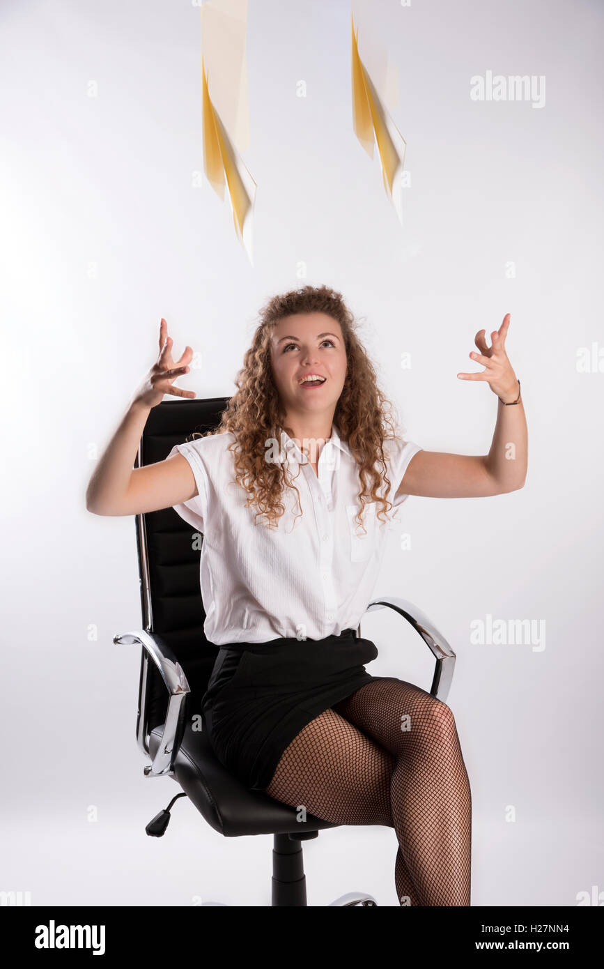 Secretary sitting on a chair and throwing paper files in the air Stock ...