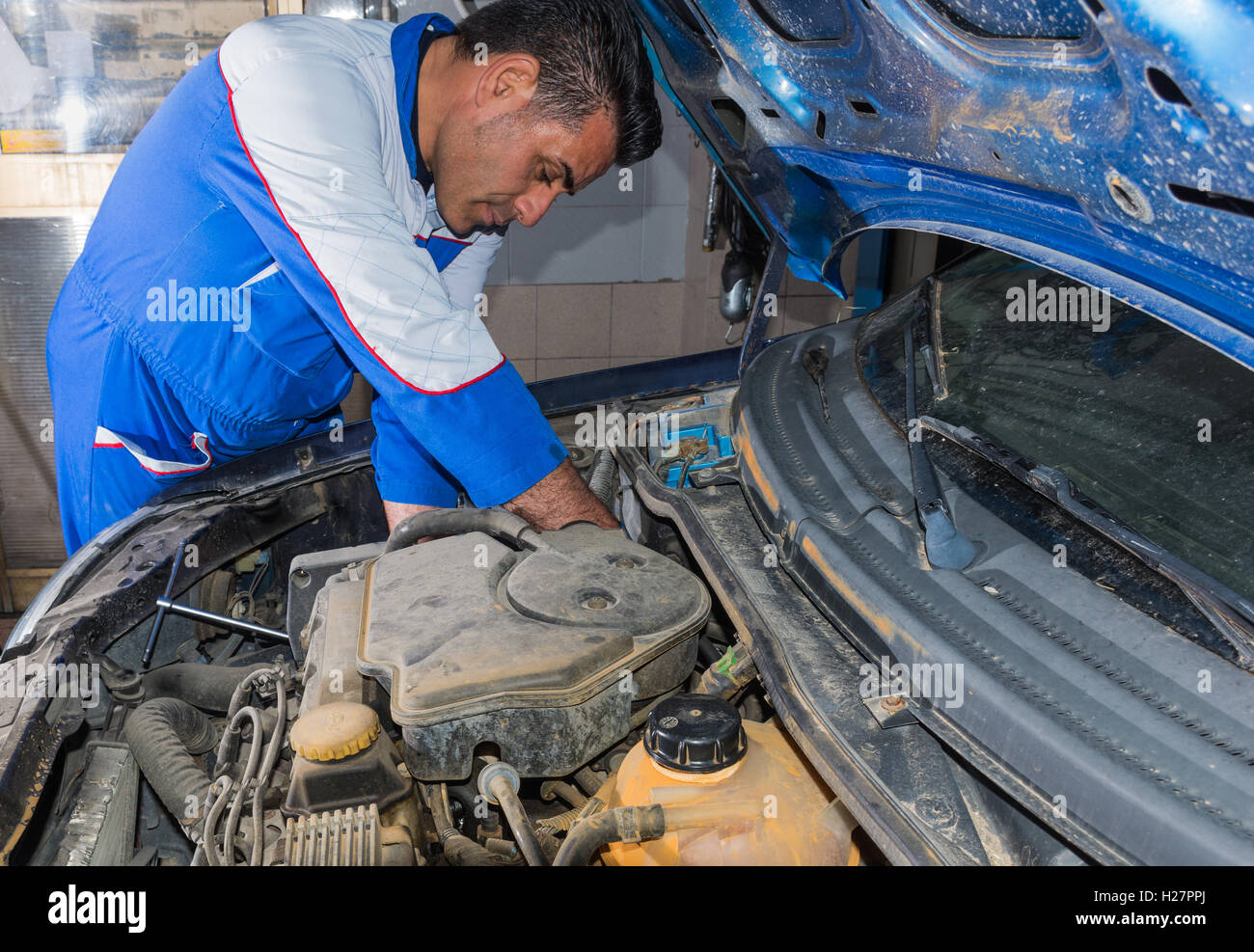 Car mechanic fixing an engine in his garage. copy space Stock Photo - Alamy