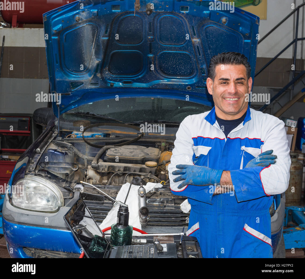 Car mechanic fixing an engine in his garage. copy space Stock Photo - Alamy