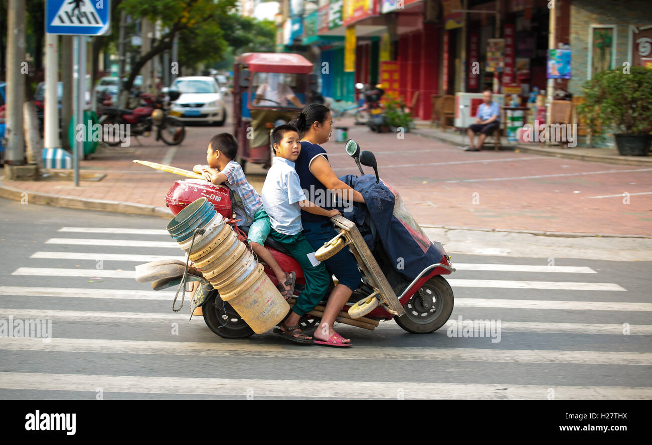 A chinese family riding motorbike dangerously carrying many items on ...