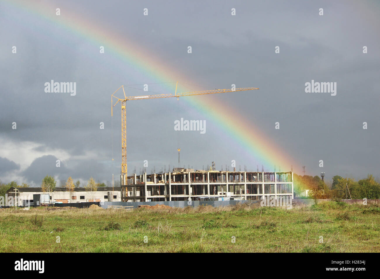bright colorful wide colorful rainbow and a crane on a construction ...