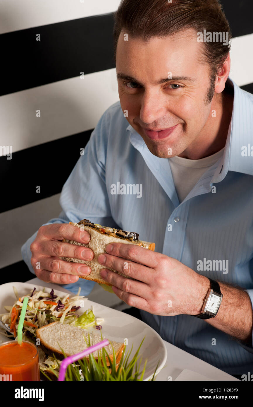 Man eating sandwich in a restaurant Stock Photo - Alamy
