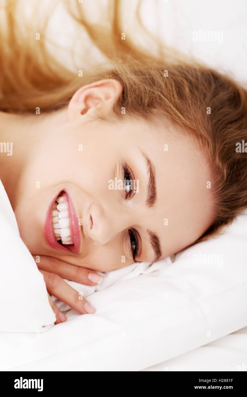 Smiling happy woman lying in bed Stock Photo - Alamy