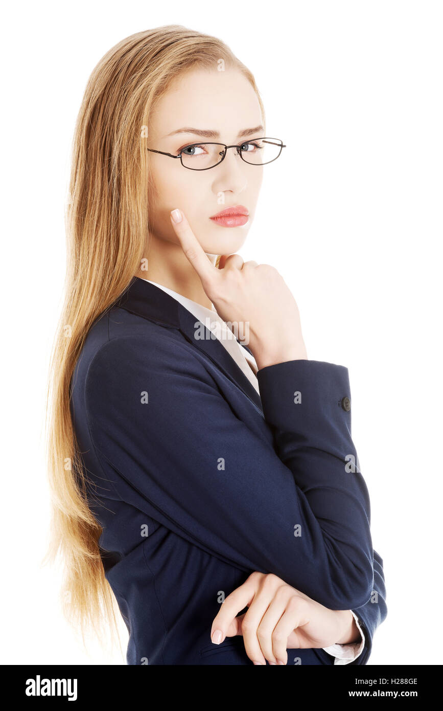 Beautiful business woman with her finger on cheek thinking Stock Photo ...