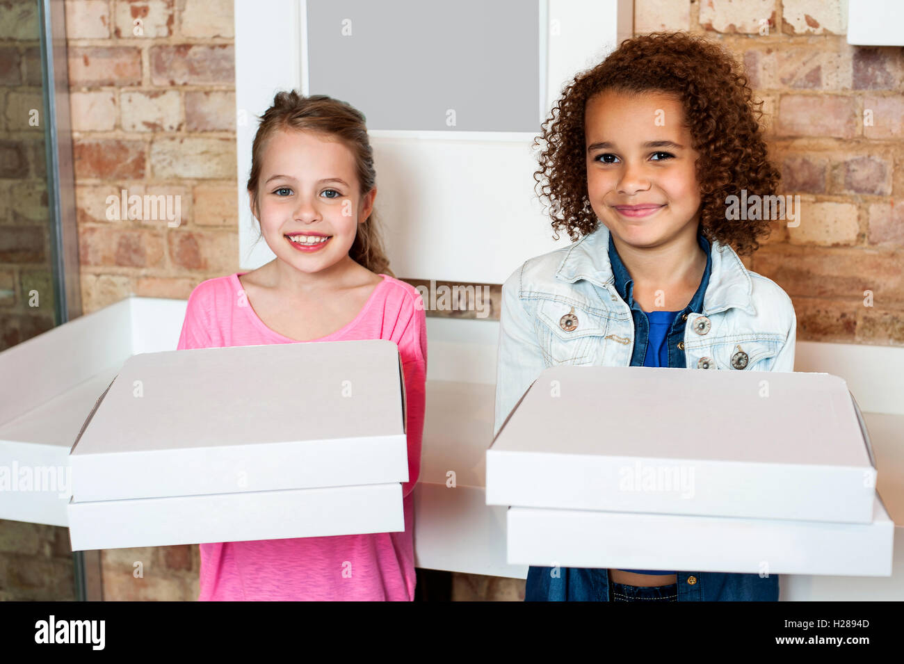 Kids holding pizza boxes Stock Photo - Alamy