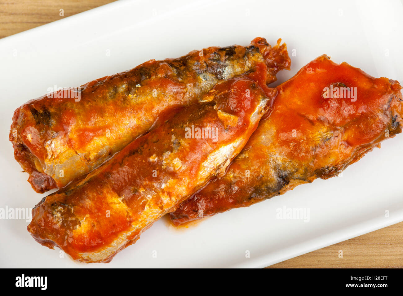 Sardines in a rich tomato sauce on a white rectangular platter Stock ...