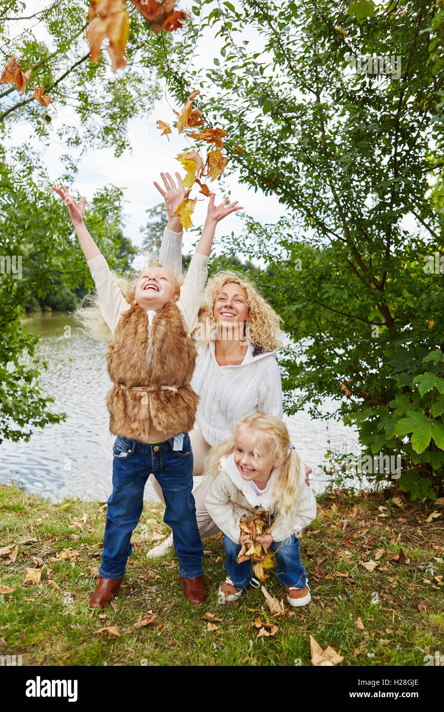 Children run and play in the fall with leaves and have fun Stock Photo ...