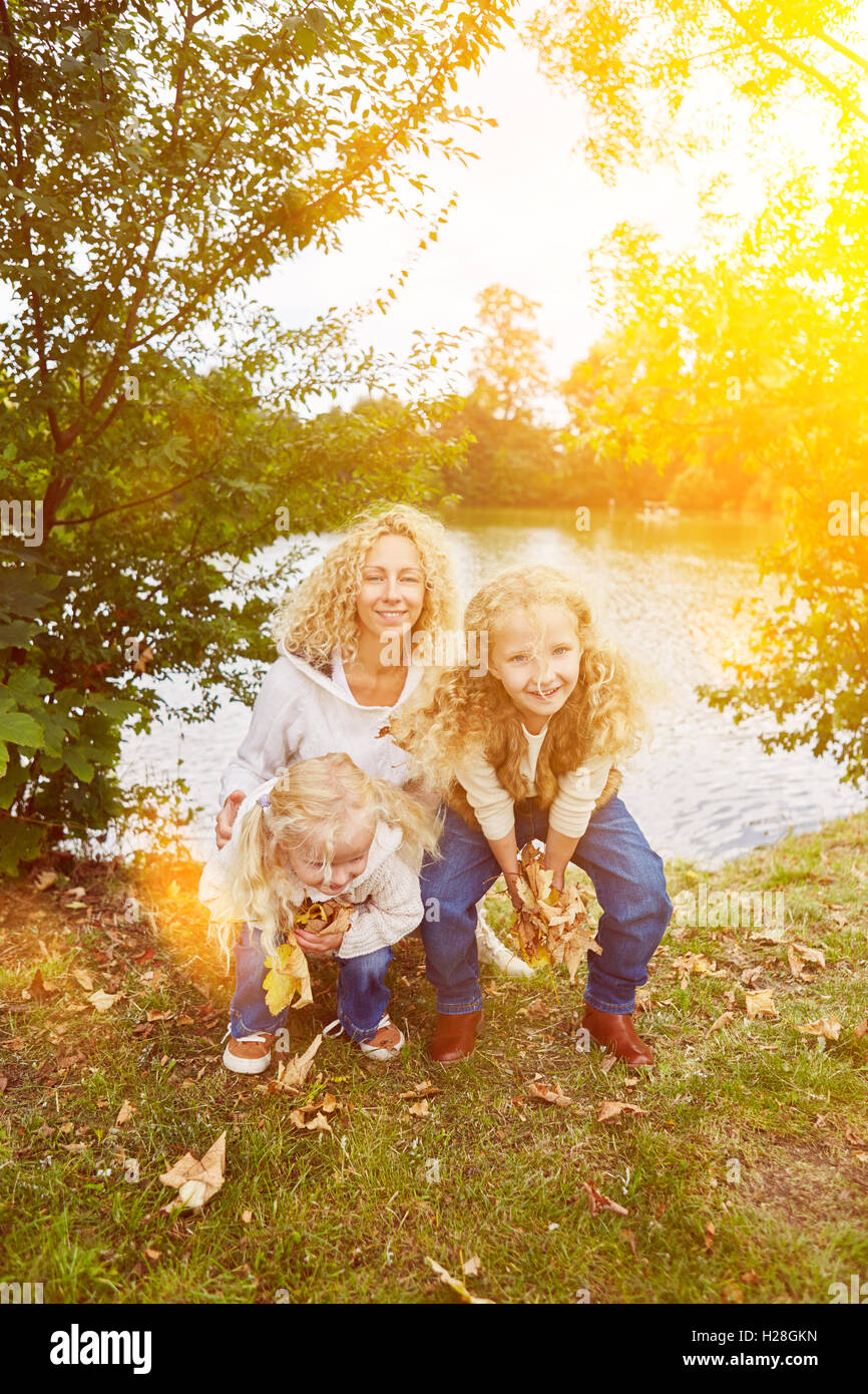 Children collecting leaves in autumn with their mother Stock Photo - Alamy