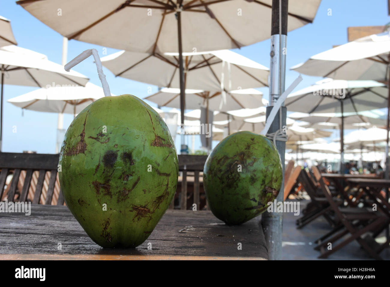 Coconut with straw ready to drink coconut water at beach restaurant ...