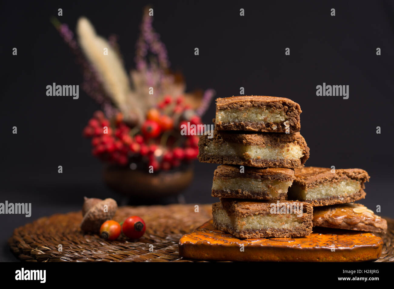 marzipan filled spicy cookies with almonds on autumn colored and dark ...