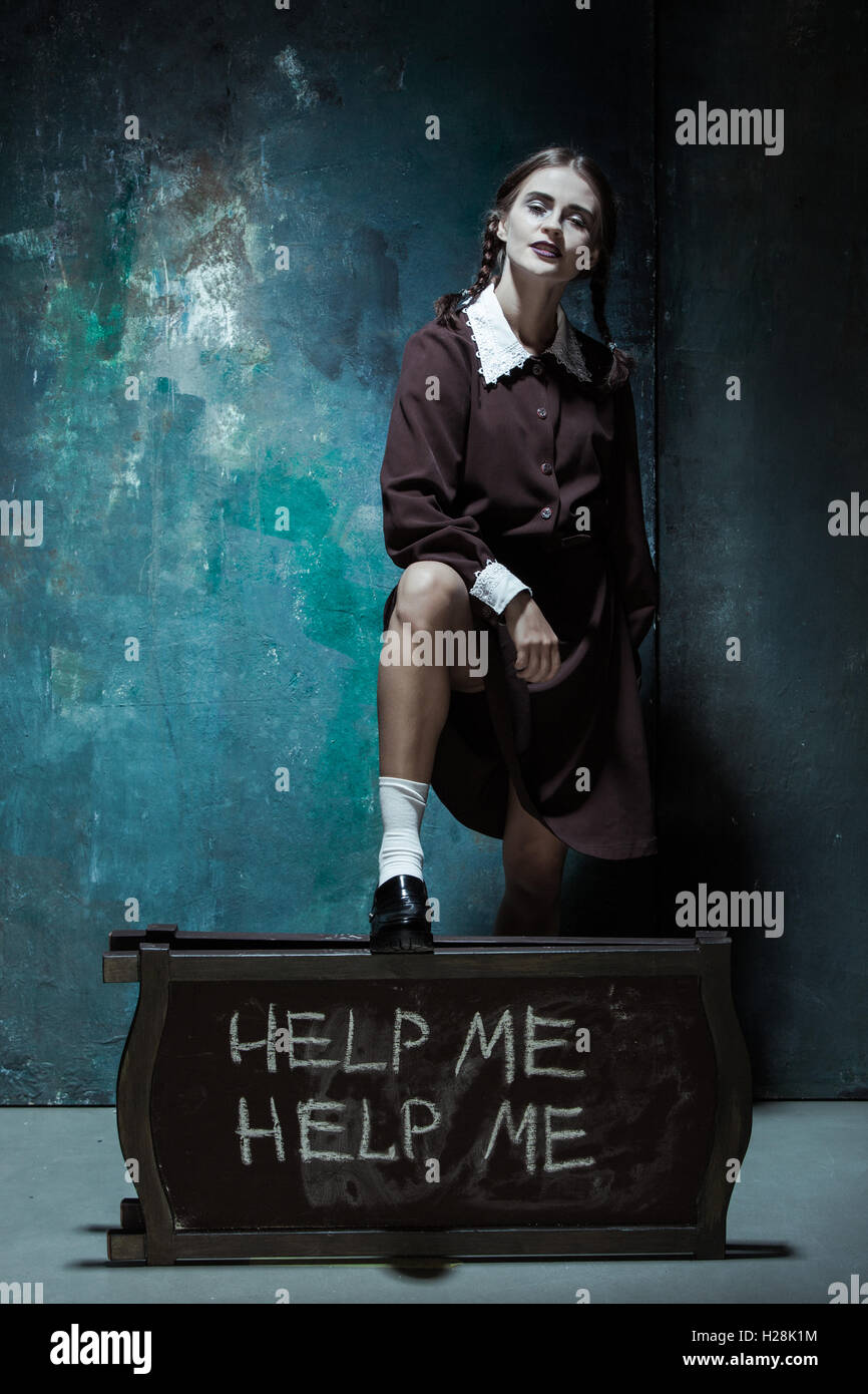 Portrait of a young smiling girl in school uniform as killer woman ...