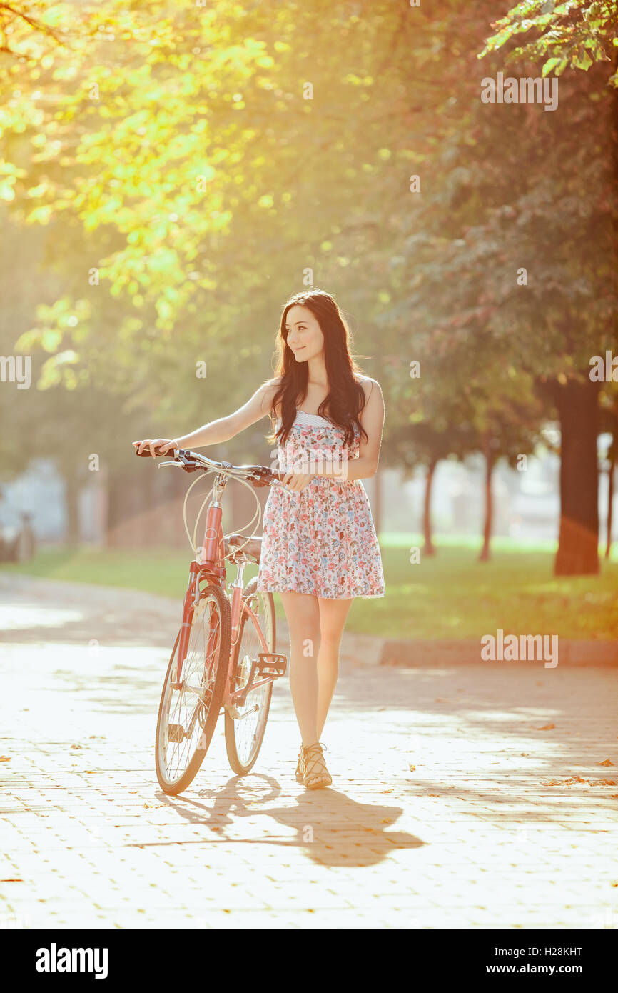 The young girl with bicycle in park Stock Photo - Alamy