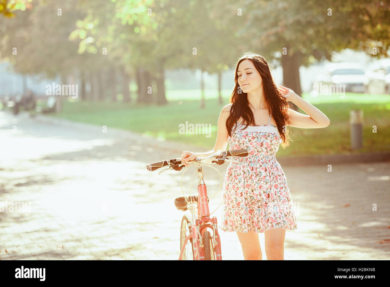 The young girl with bicycle in park Stock Photo - Alamy